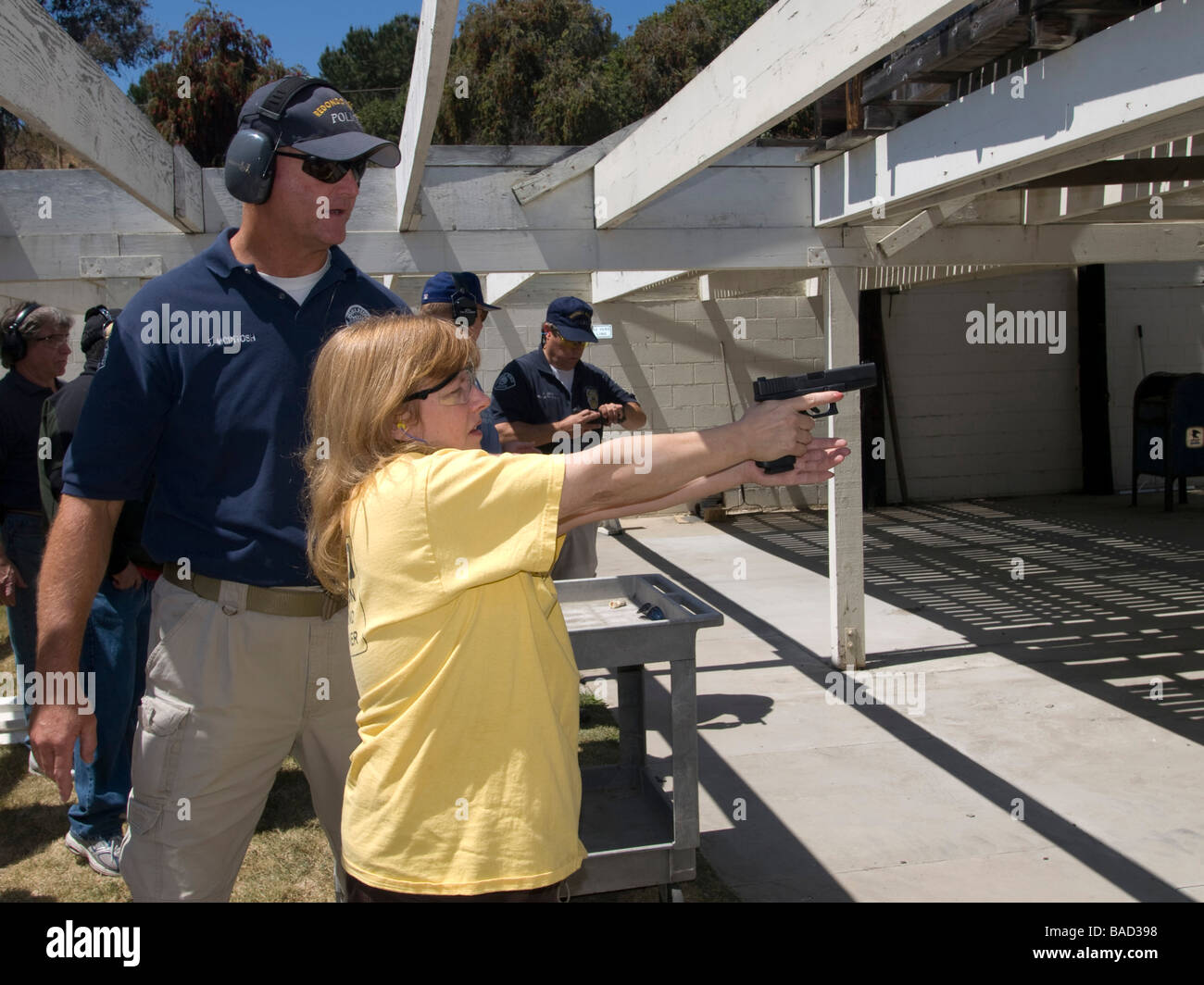 Police officer instructs female citizen police academy member in using ...