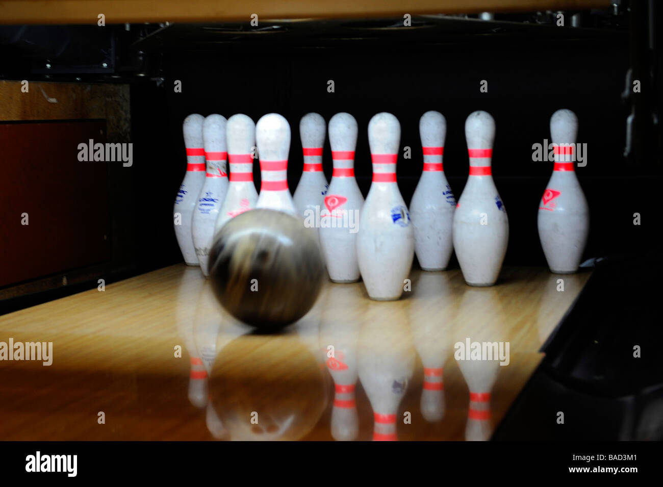 Black Bowling Ball Hitting White Bowling Pins Stock Photo - Alamy