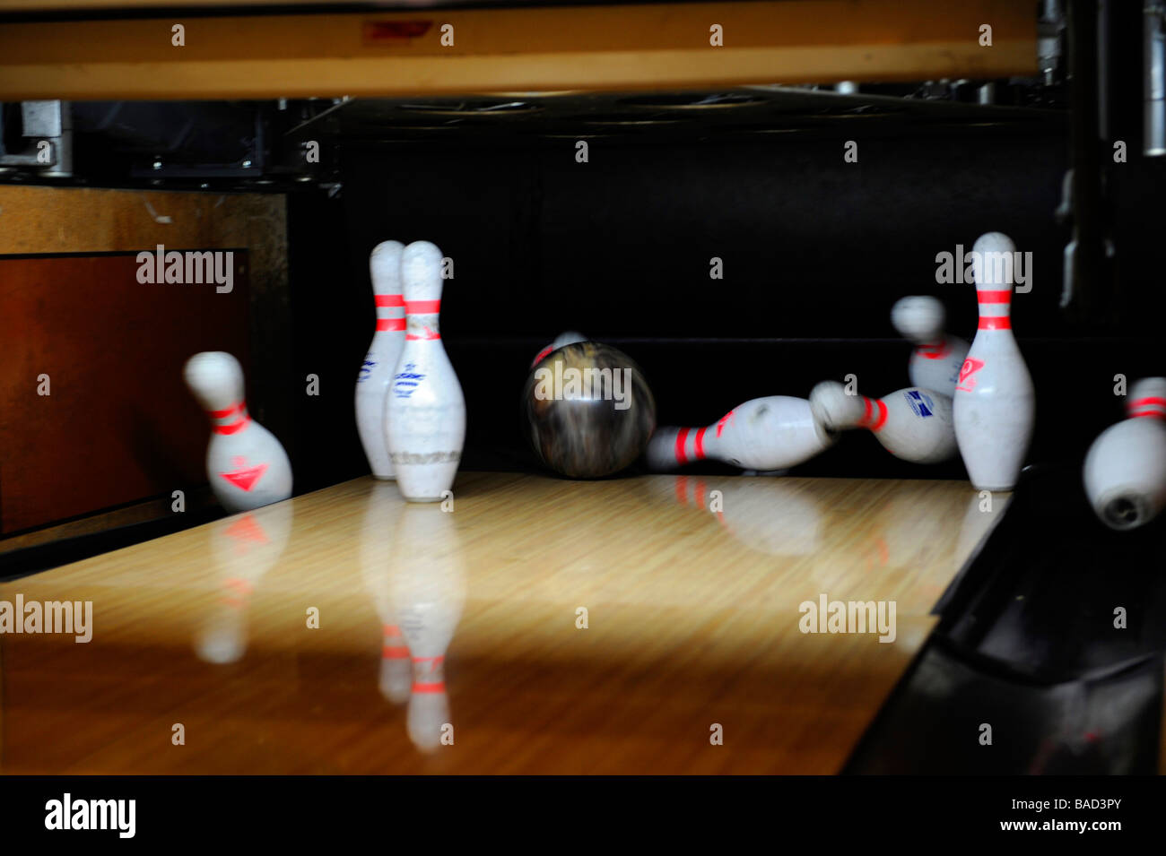 Black Bowling Ball Hitting White Bowling Pins Stock Photo - Alamy