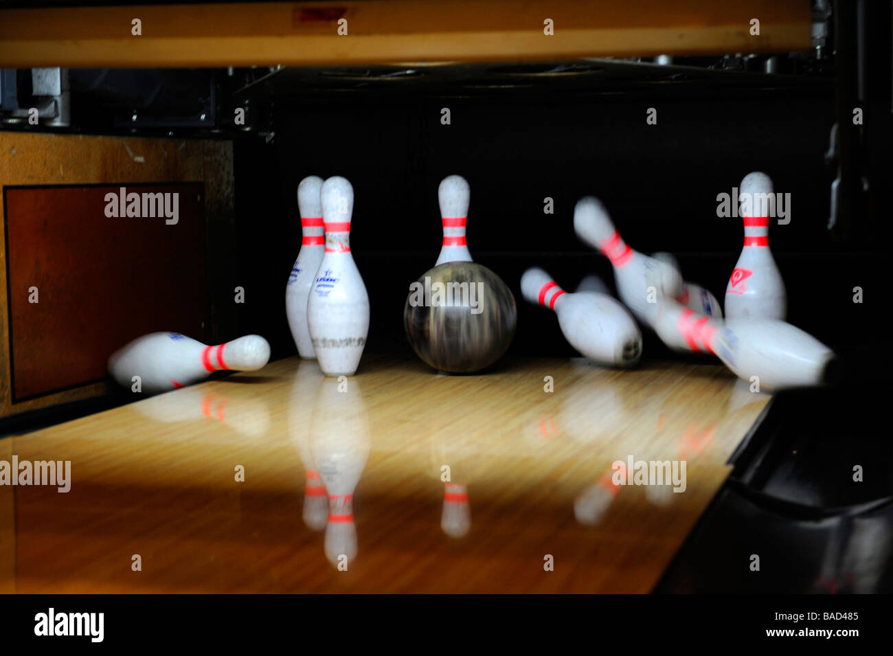Black Bowling Ball Hitting White Bowling Pins Stock Photo - Alamy