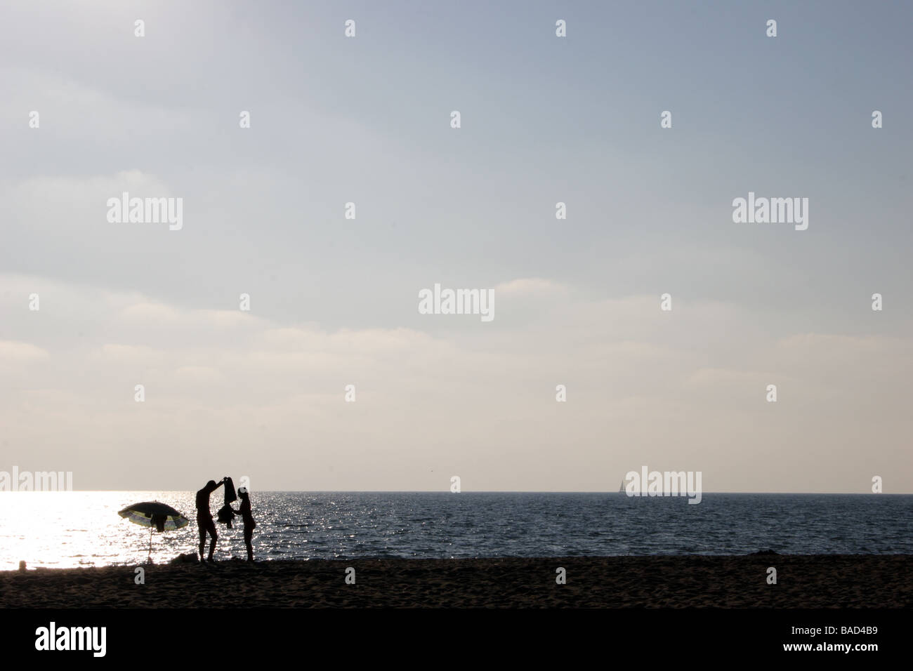 Young couple on the beach in contrast Stock Photo - Alamy