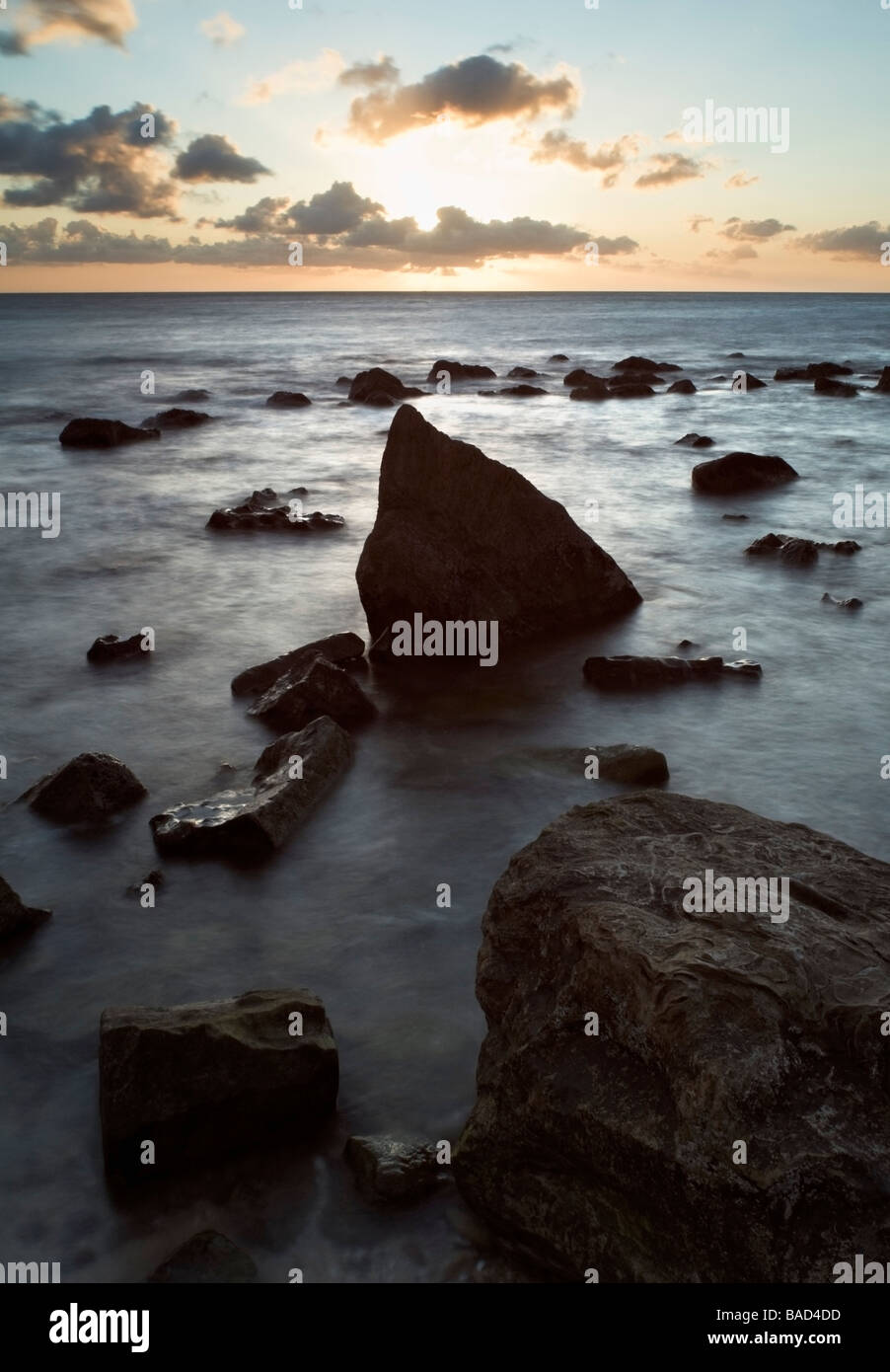 Rocks in shallow water by the shore Stock Photo - Alamy