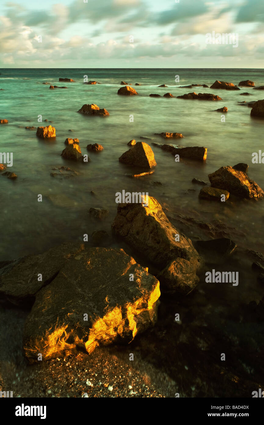 Rocks in shallow water by the shore Stock Photo - Alamy
