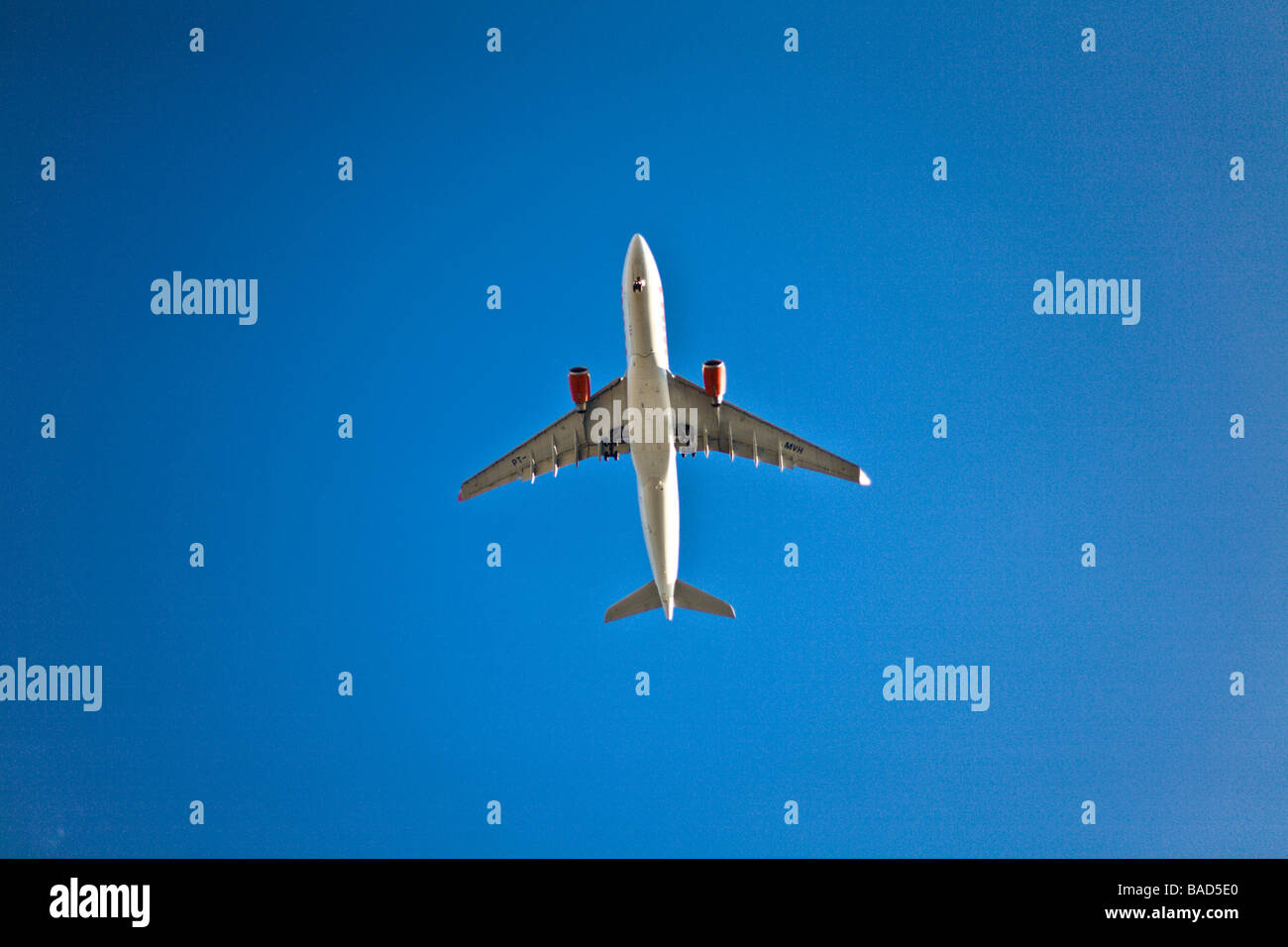 View on a Plane from below on clear blue sky Stock Photo - Alamy