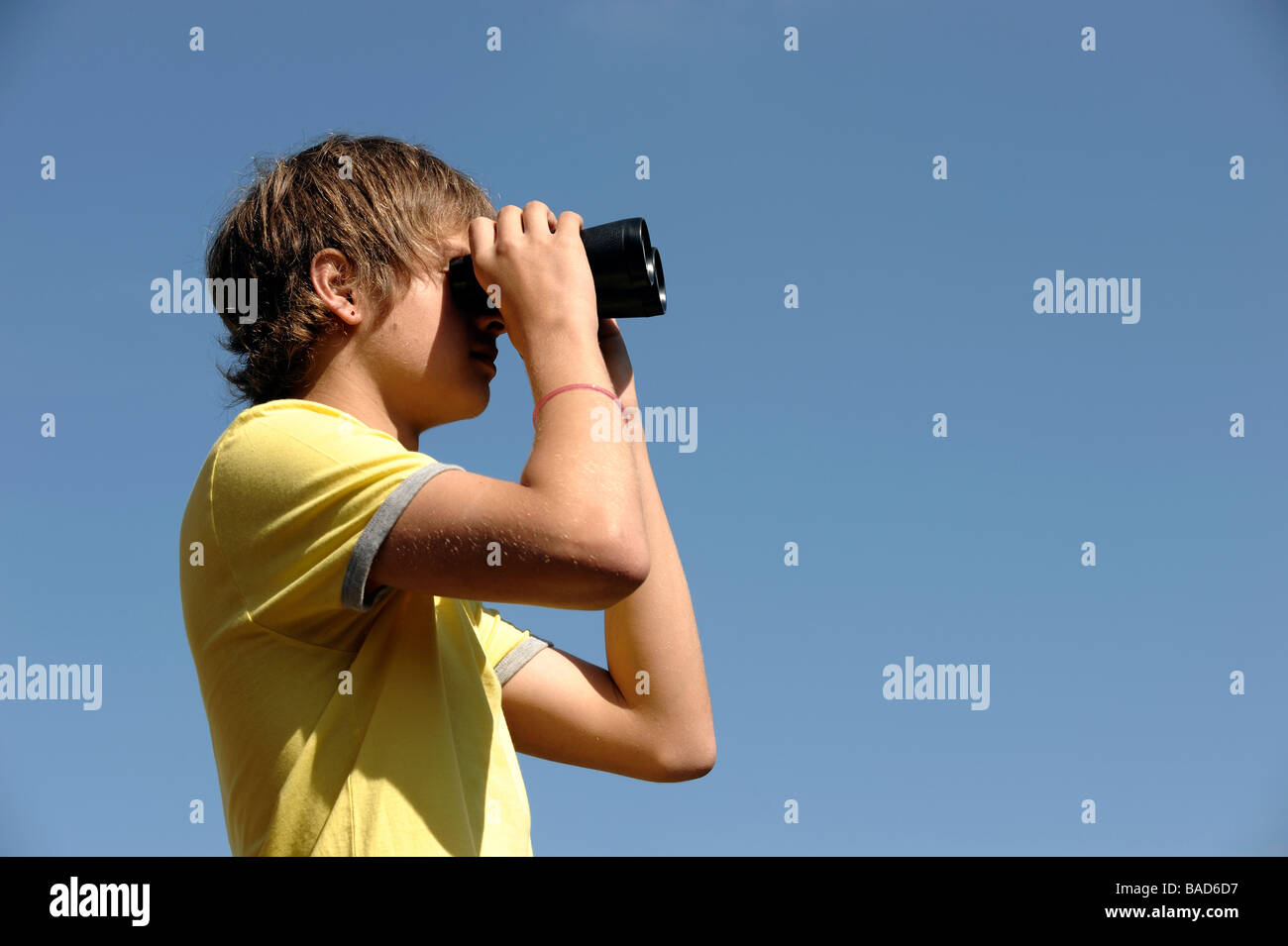 Boy looking through binoculars Stock Photo - Alamy