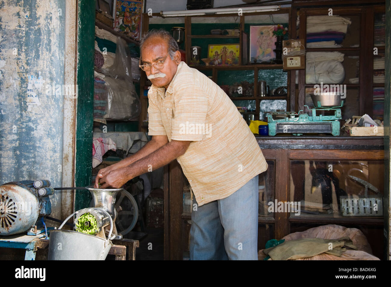 Shopkeeper using mechanical mincer outside his shop, Bikaner, Rajasthan ...
