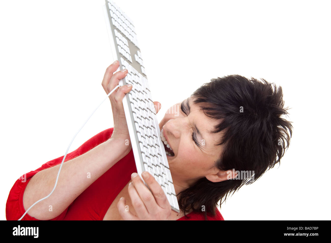 woman biting a computer keyboard in frustration Stock Photo - Alamy