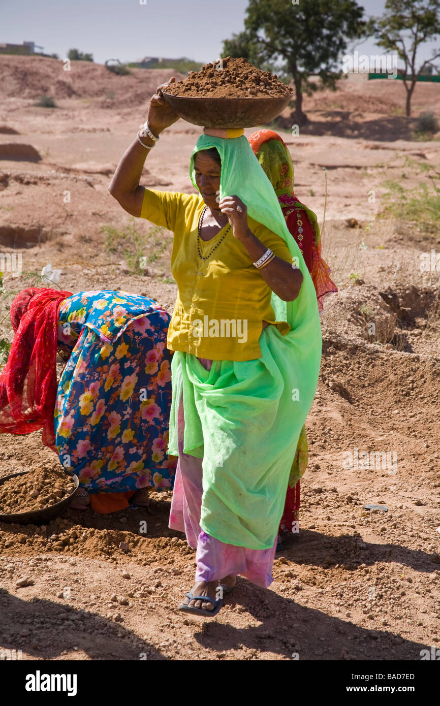 Woman labourer carrying container of soil on her head, Keechen, near ...