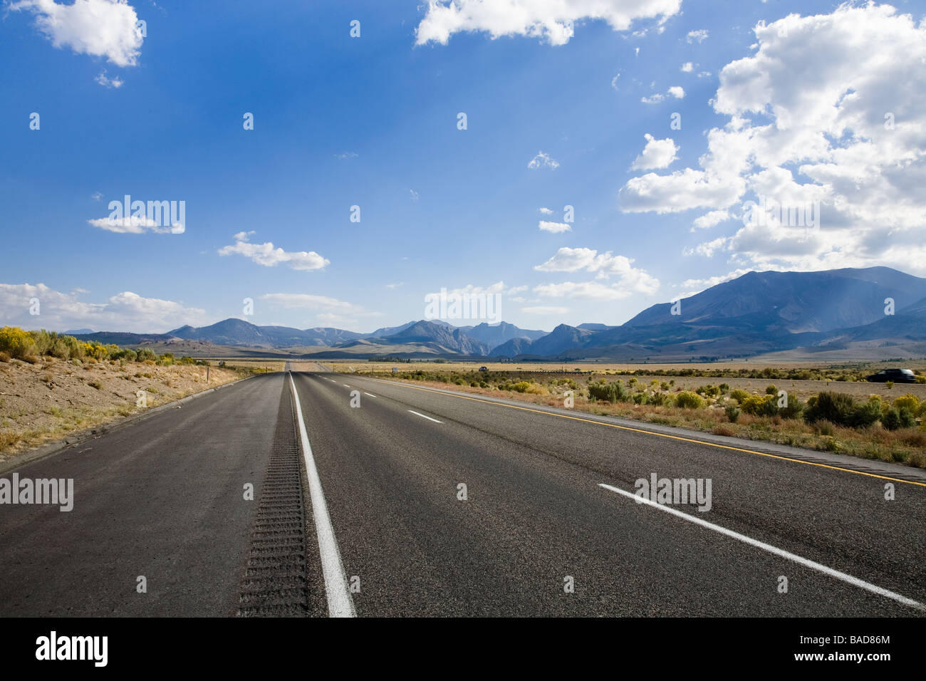 Endless road on the highway, with blue skies and clouds Stock Photo - Alamy