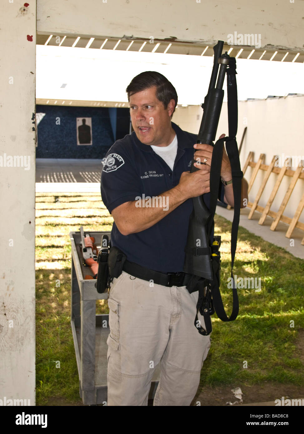 Police officer instructor holds a Reminton 12 guage shotgun on the ...