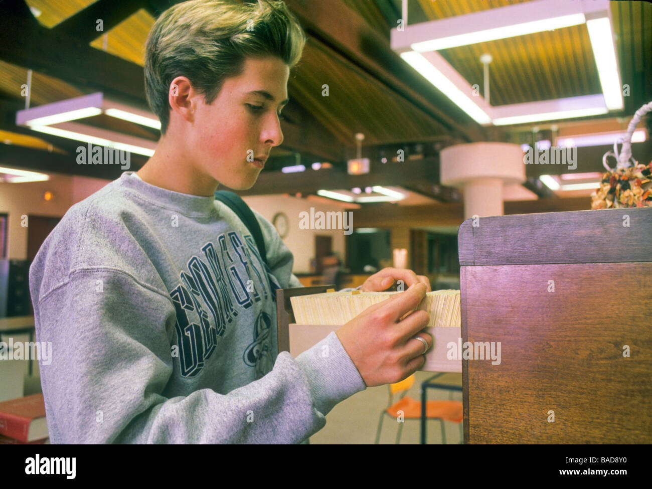 Teen boy research card index file book library find locate pick choose ...