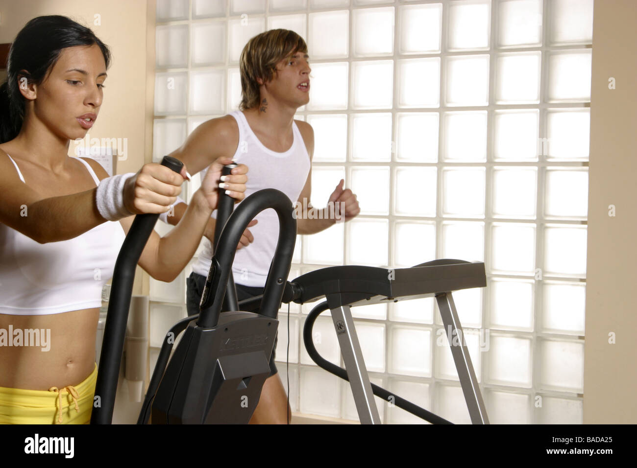 Two people on exercise bikes Stock Photo - Alamy