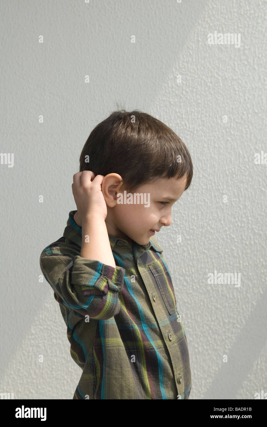 Young boy scratching his itchy head Stock Photo - Alamy