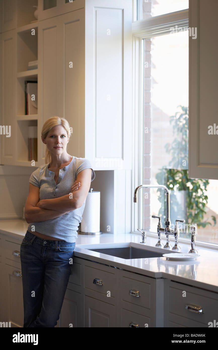 Woman Leaning on Kitchen Counter Stock Photo - Alamy