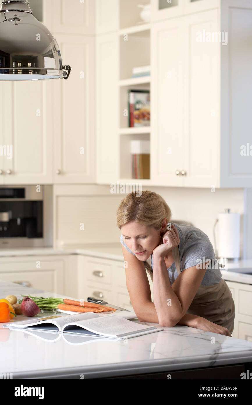 Woman Reading Cookbook in Kitchen Stock Photo - Alamy