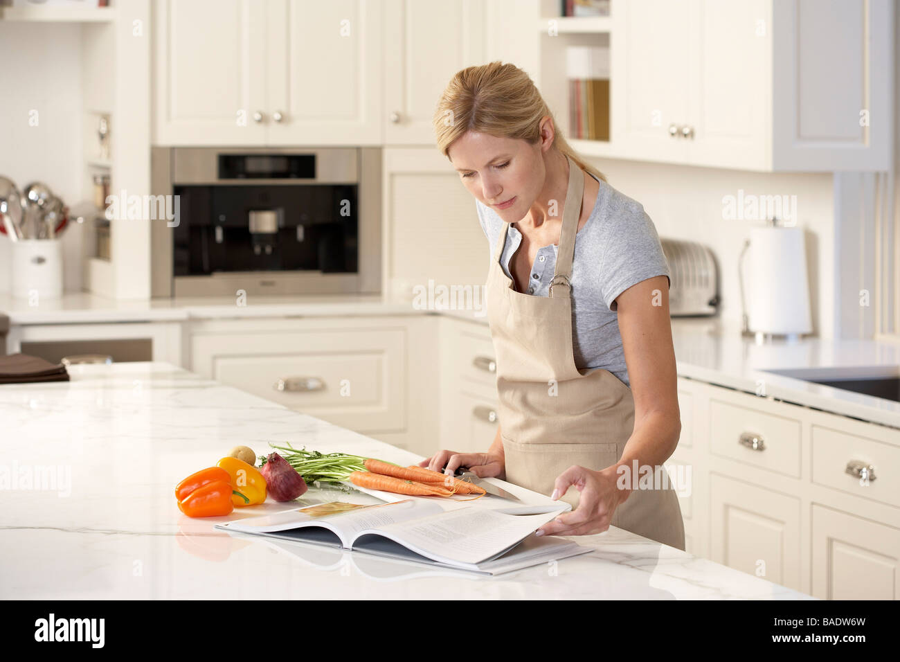Woman Reading Cookbook in Kitchen Stock Photo - Alamy