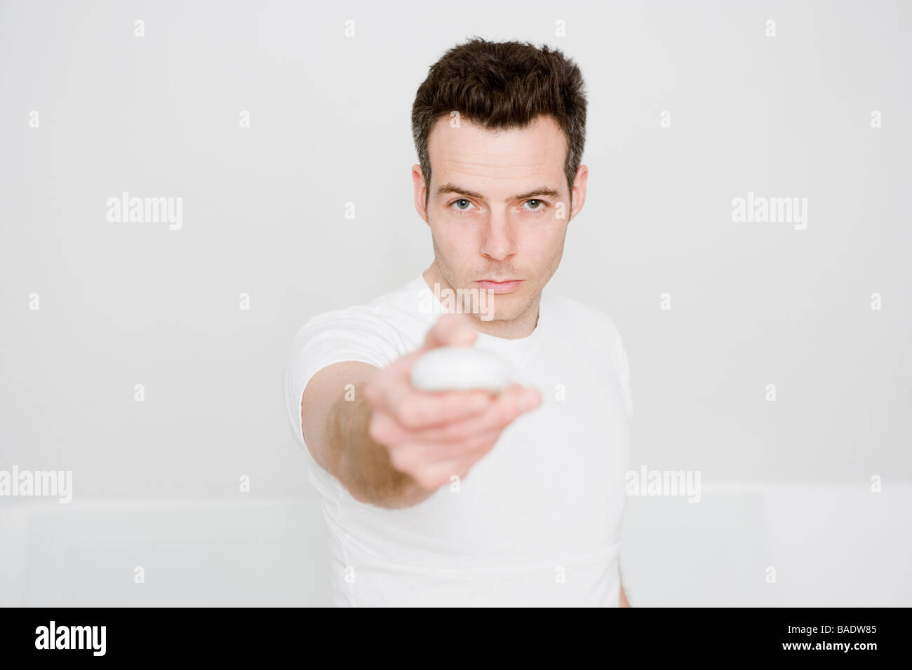 man pointing remote controls at camera Stock Photo - Alamy