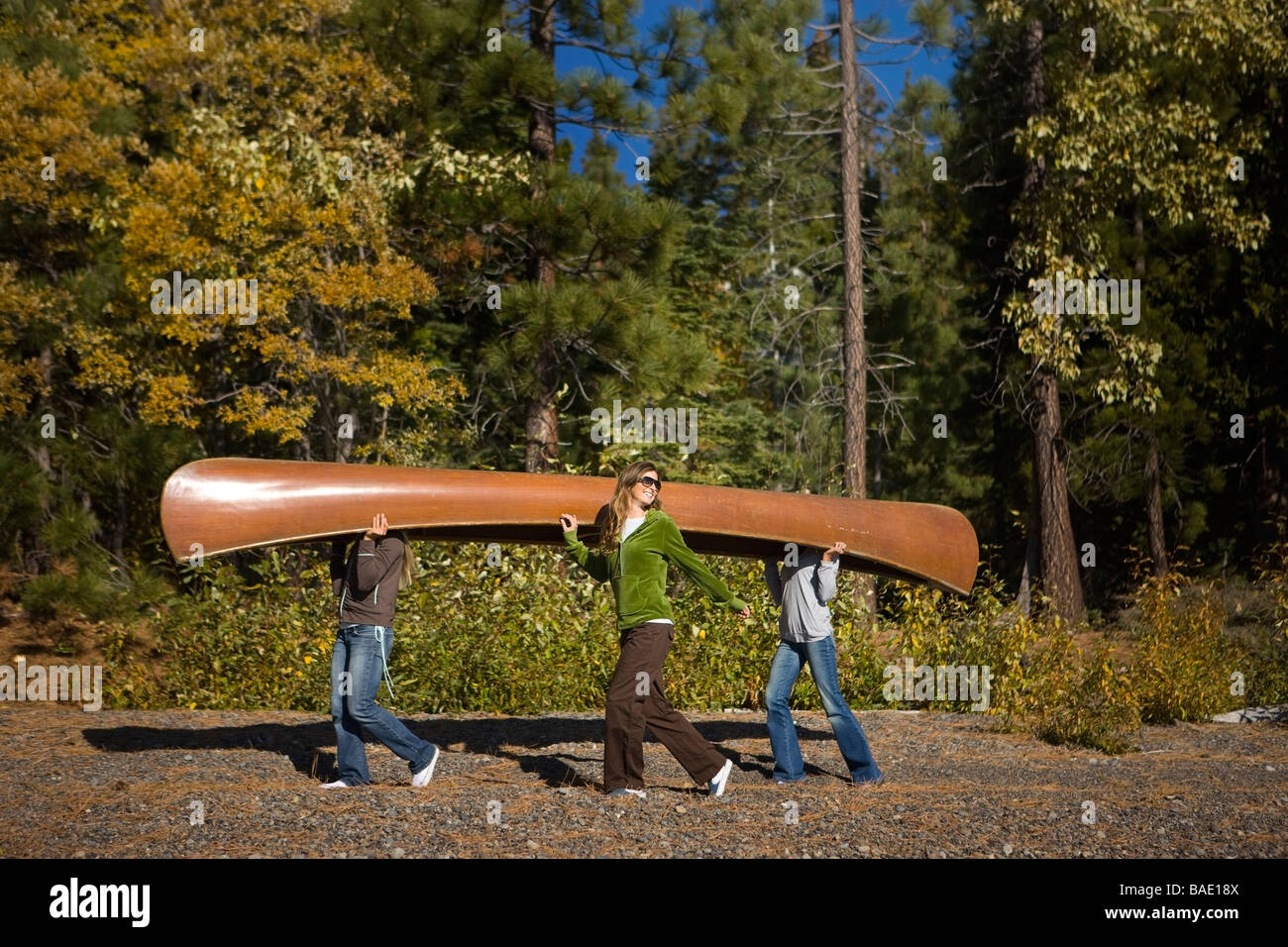 Three Women Carrying Canoe in the Forest Stock Photo - Alamy