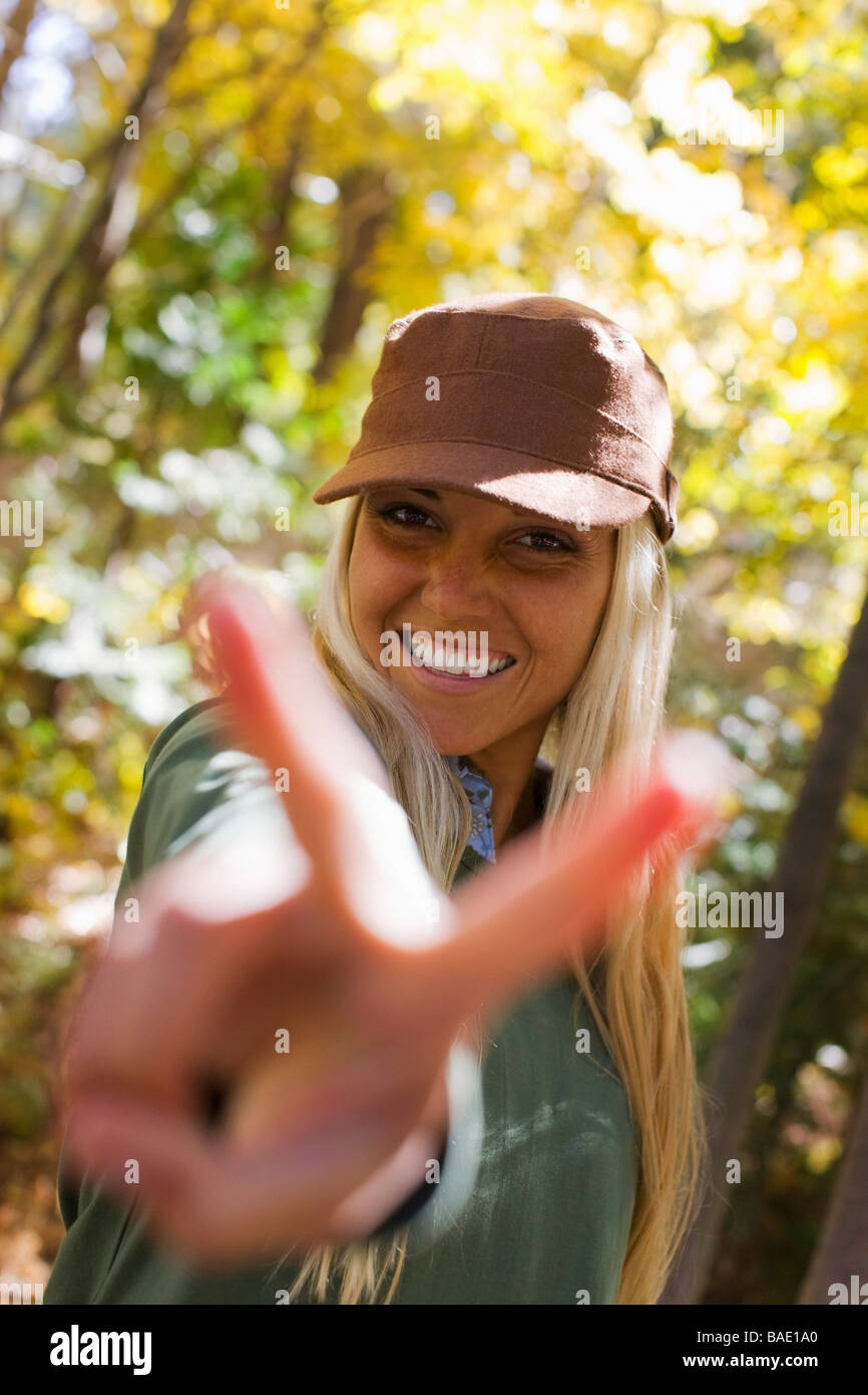 Portrait of Woman Making Peace Sign Stock Photo - Alamy