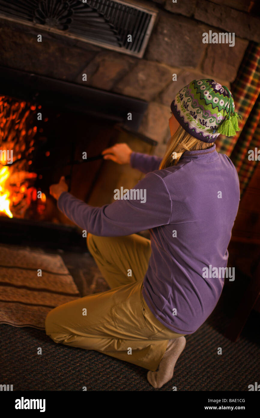 Woman Stoking a Fire Stock Photo - Alamy