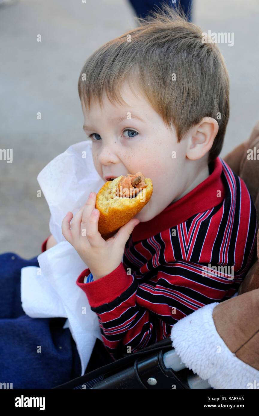 Young male child eats corn dog at Strawberry Festival Plant City ...