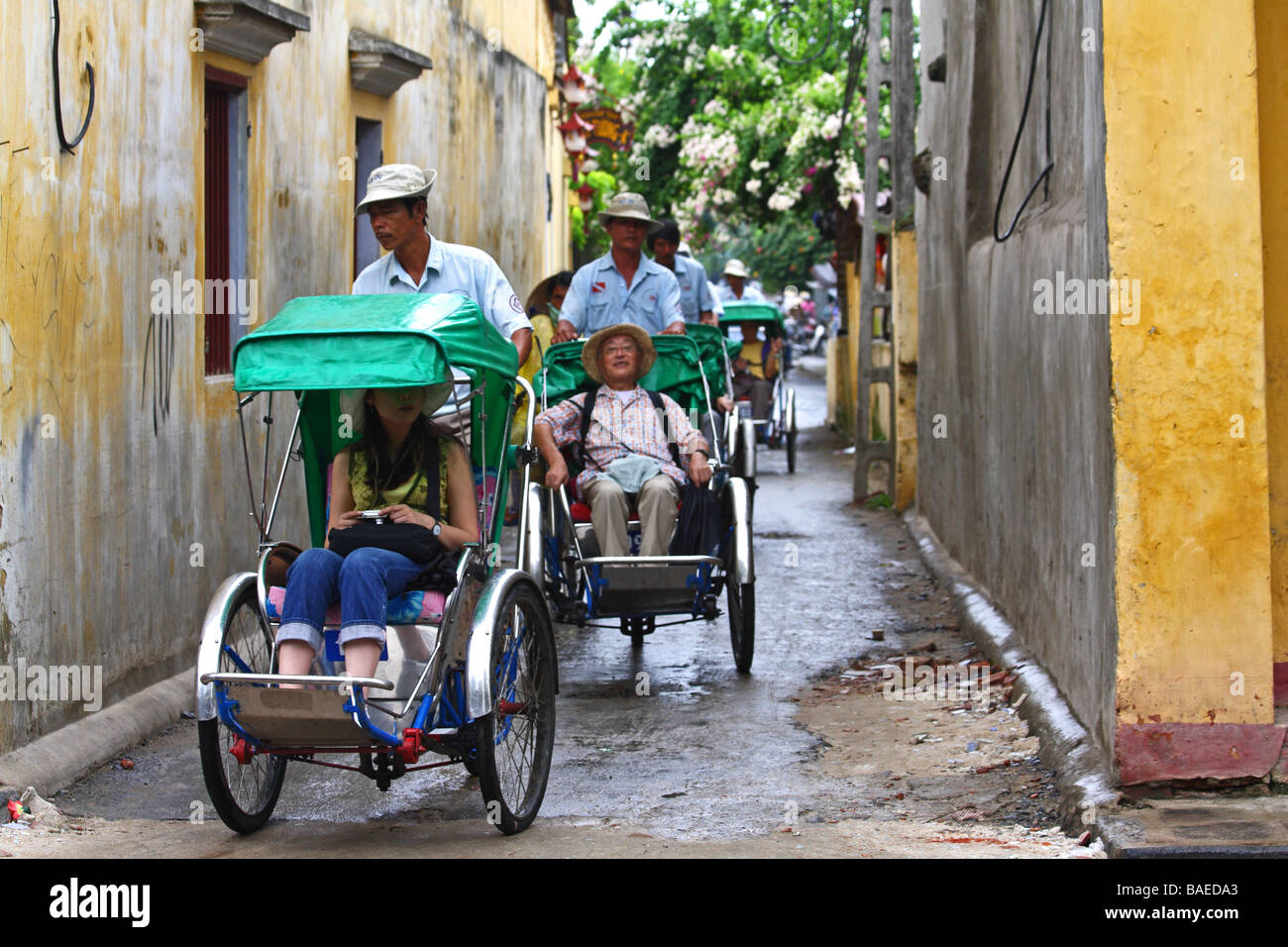 Street scene. Cyclo driver wih some tourist in the street of Hoi An ...