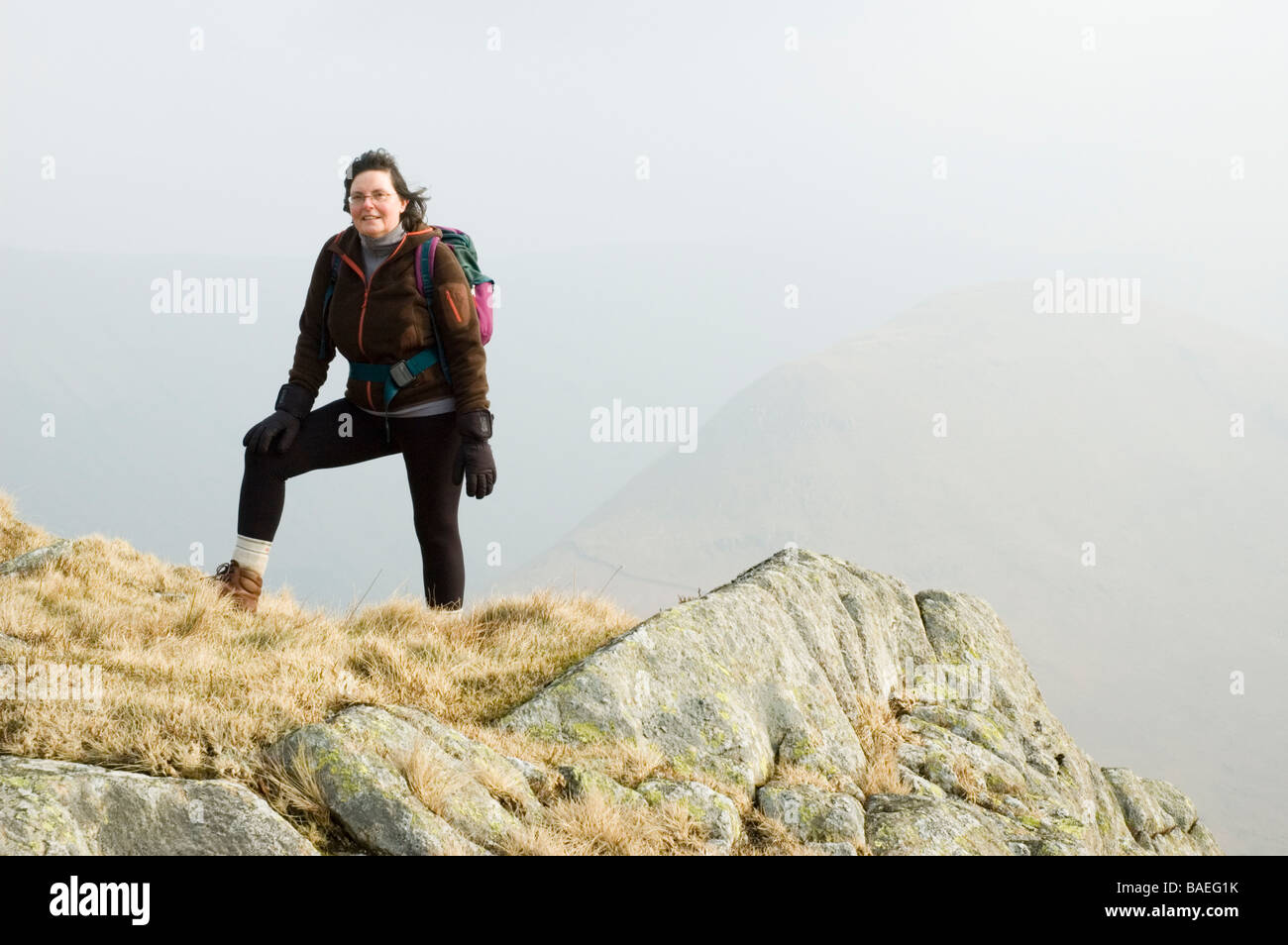 A fell walker pauses on the path up Beda Fell in the English Lake ...