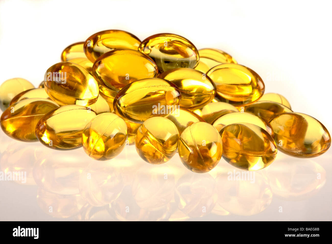 Golden pills with transparent medicine lying on a backlit background ...