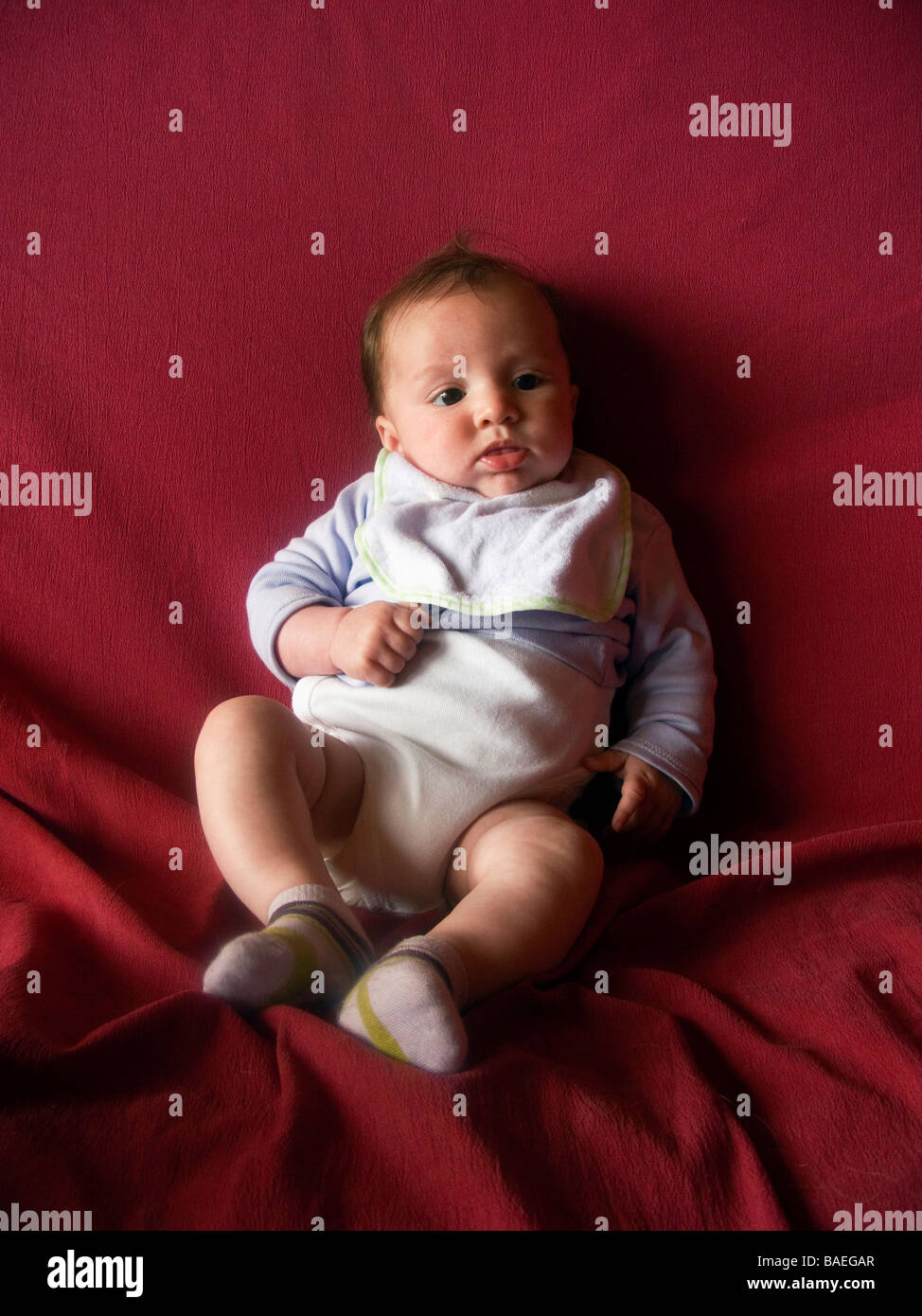 Bay boy sat on red sofa Stock Photo - Alamy