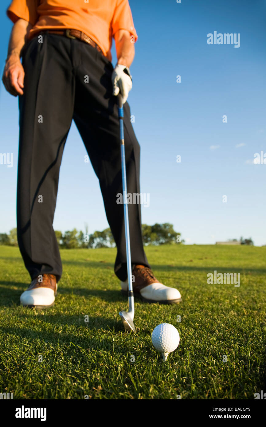 GOLF Adult middle aged male practice hitting off of tee at public ...