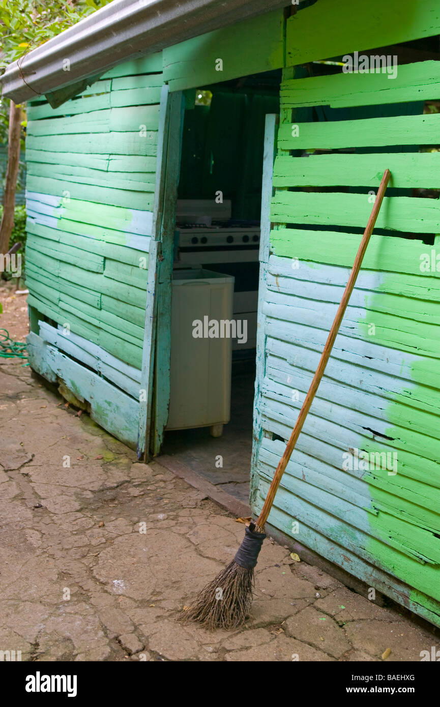 Broom leaning against green wall Stock Photo - Alamy