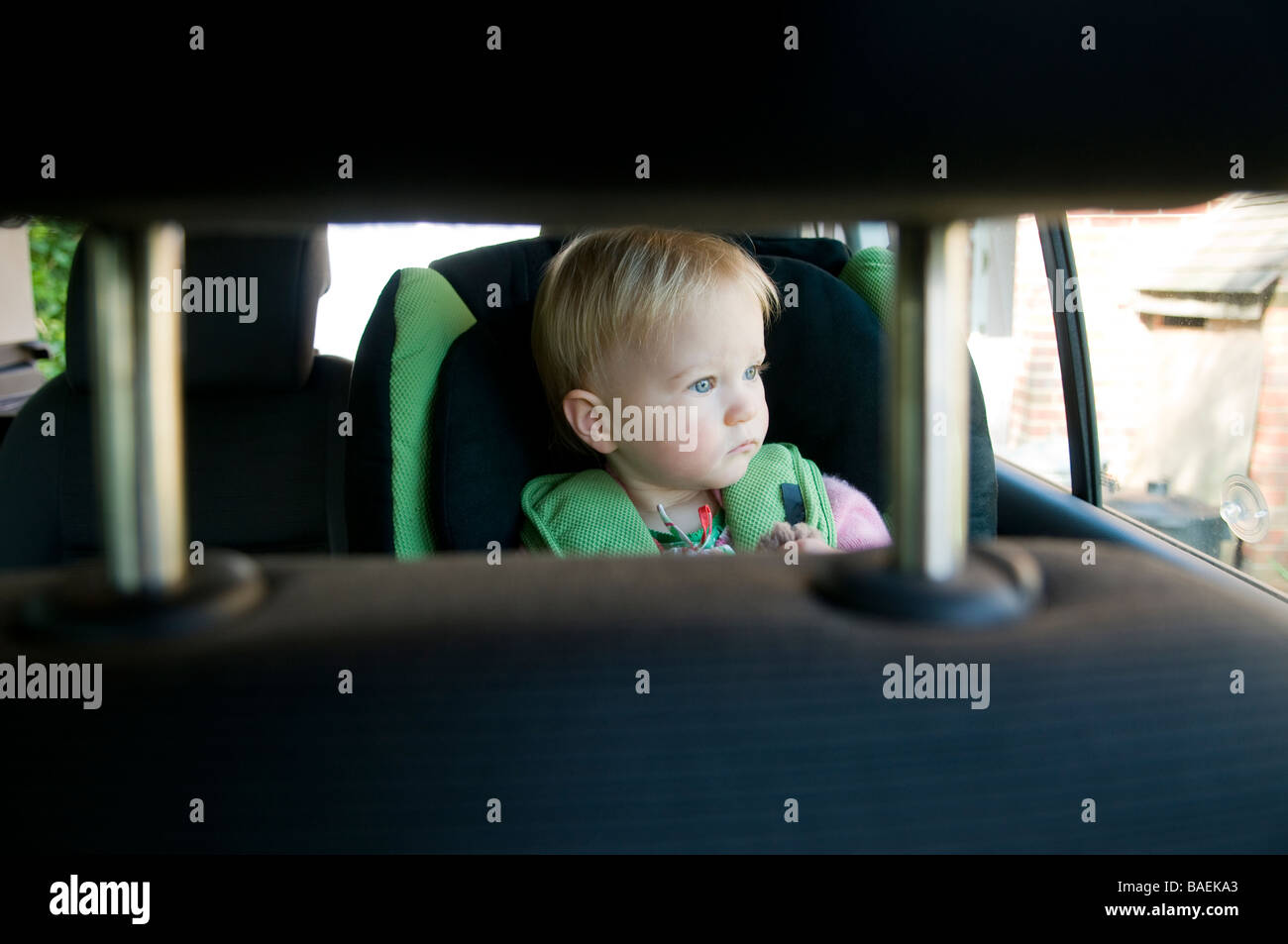 BABY GIRL CHILD IN CAR SEAT LOOKING OUT OF THE REAR WINDOW Stock Photo ...
