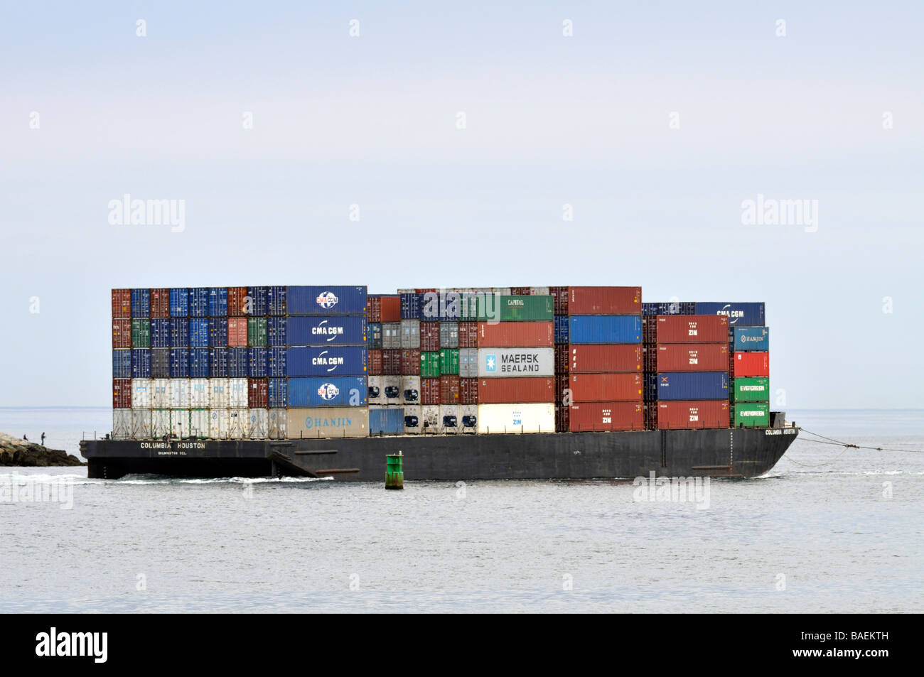 Barge at sea loaded with metal shipping containers stacked on top of ...