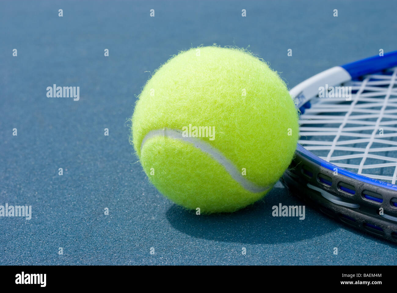 Tennis ball and racket on court Stock Photo - Alamy