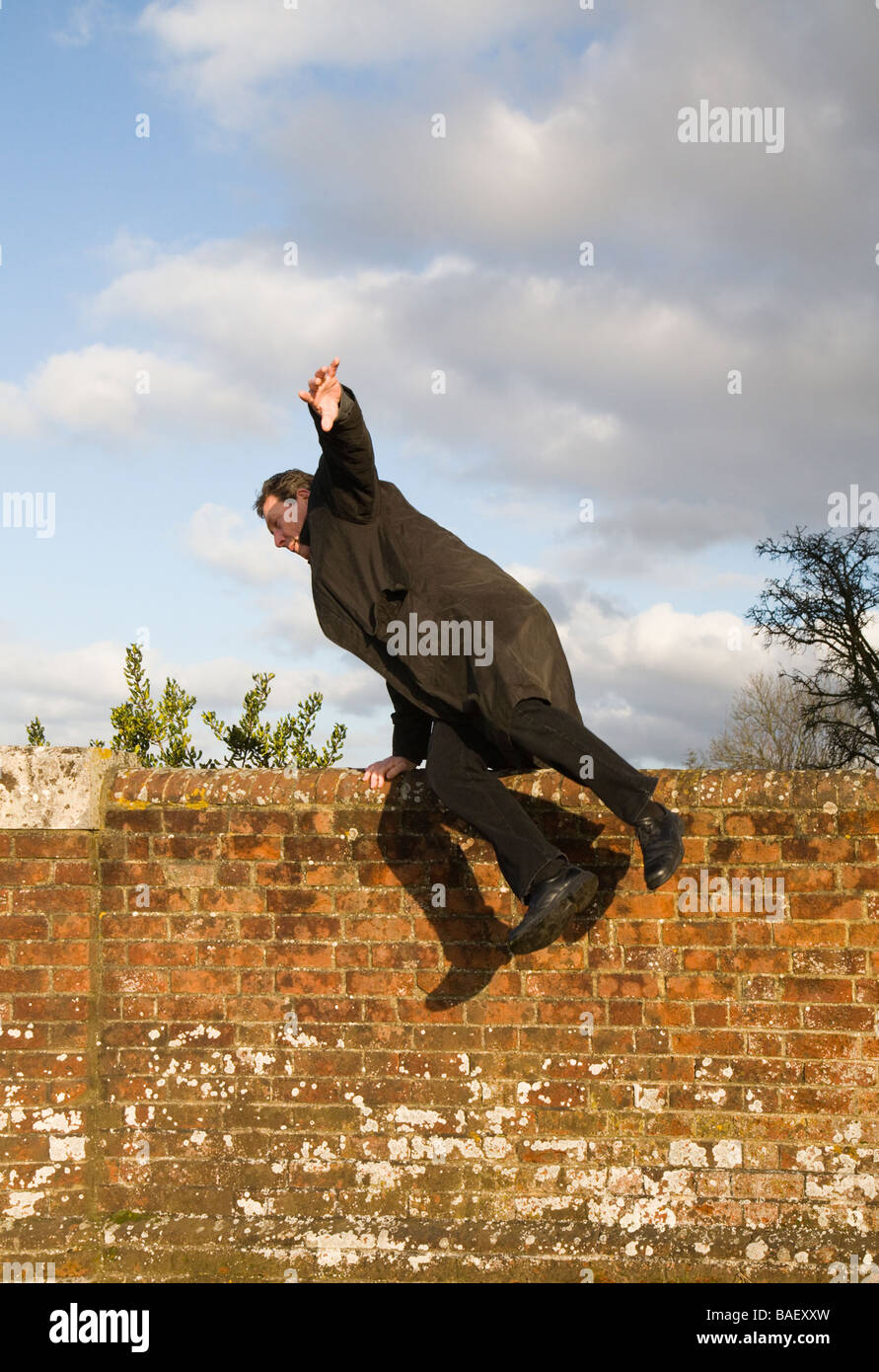 A man jumping over a brick wall. UK Stock Photo - Alamy