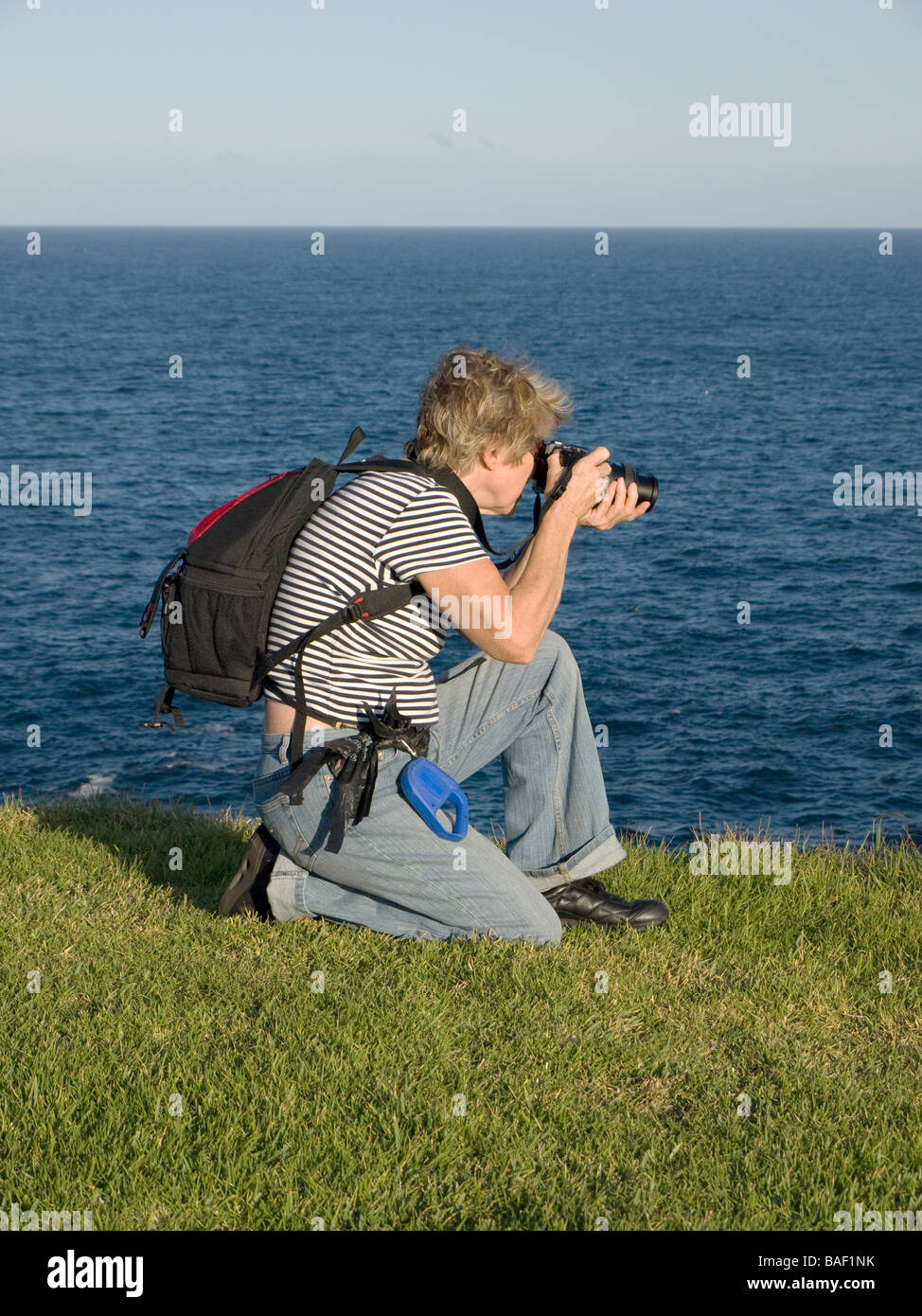 Lady crouching to take photograph with a DSLR camera Stock Photo - Alamy