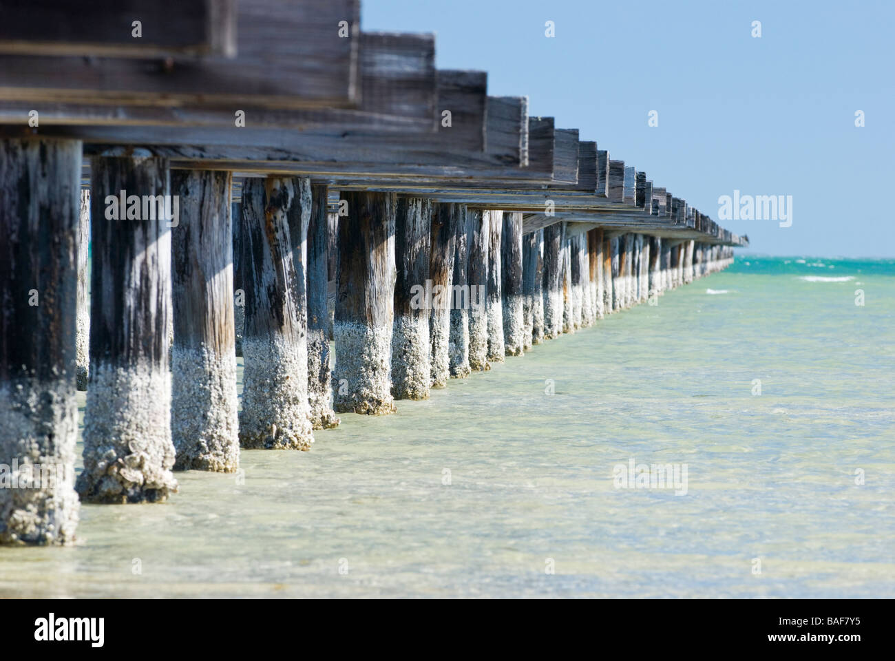 Abandoned dock reaching out into azure waters of the Gulf of Mexico at ...