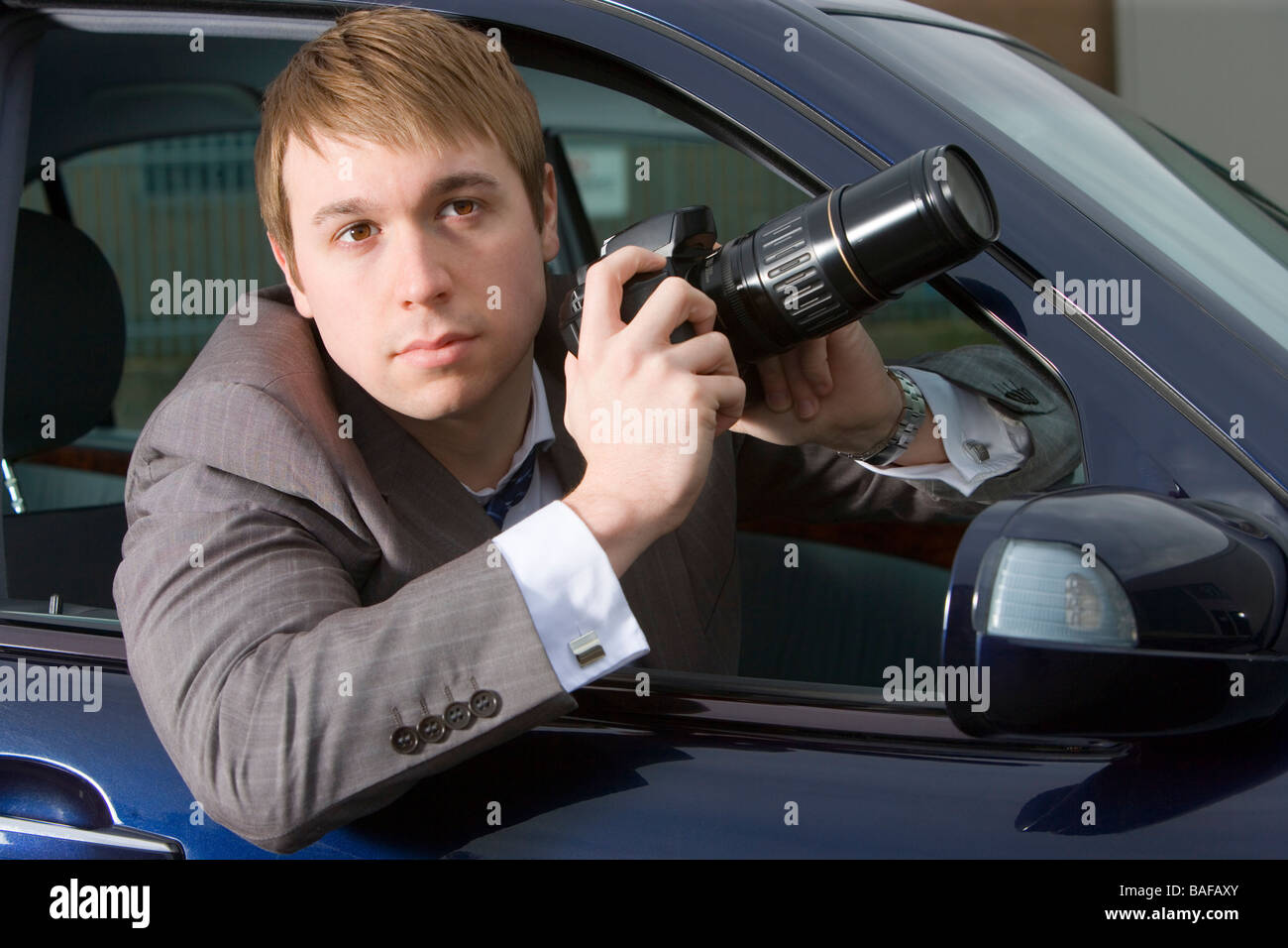 Man doing surveillance with a camera from his car Stock Photo - Alamy