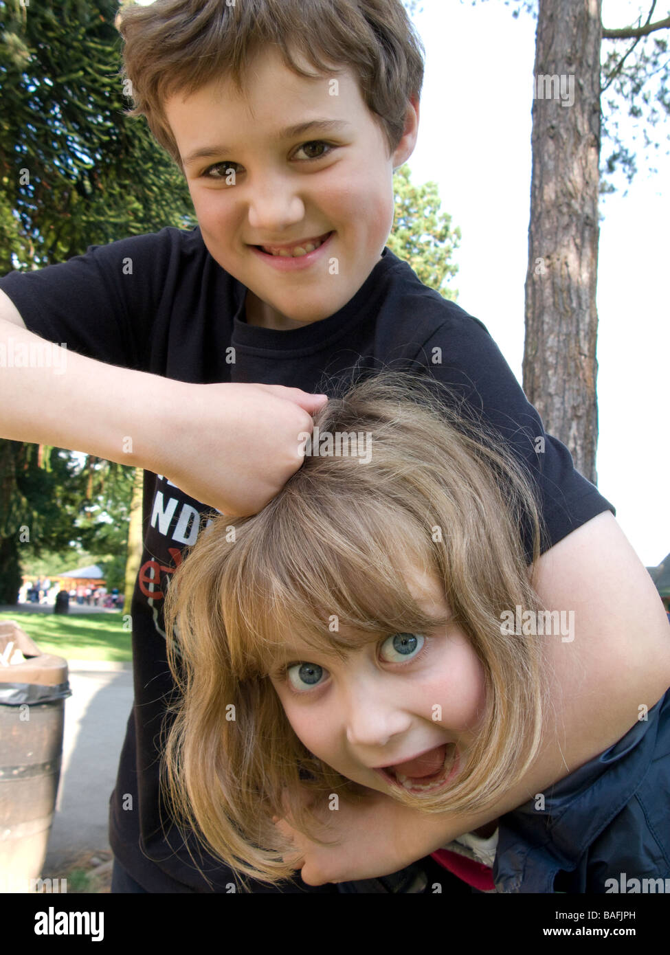 Young boy and girl brother and sister play fighting in head lock FULLY ...