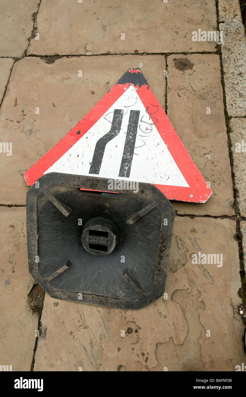 Road Narrows traffic warning sign fallen over on pavement Stock Photo ...
