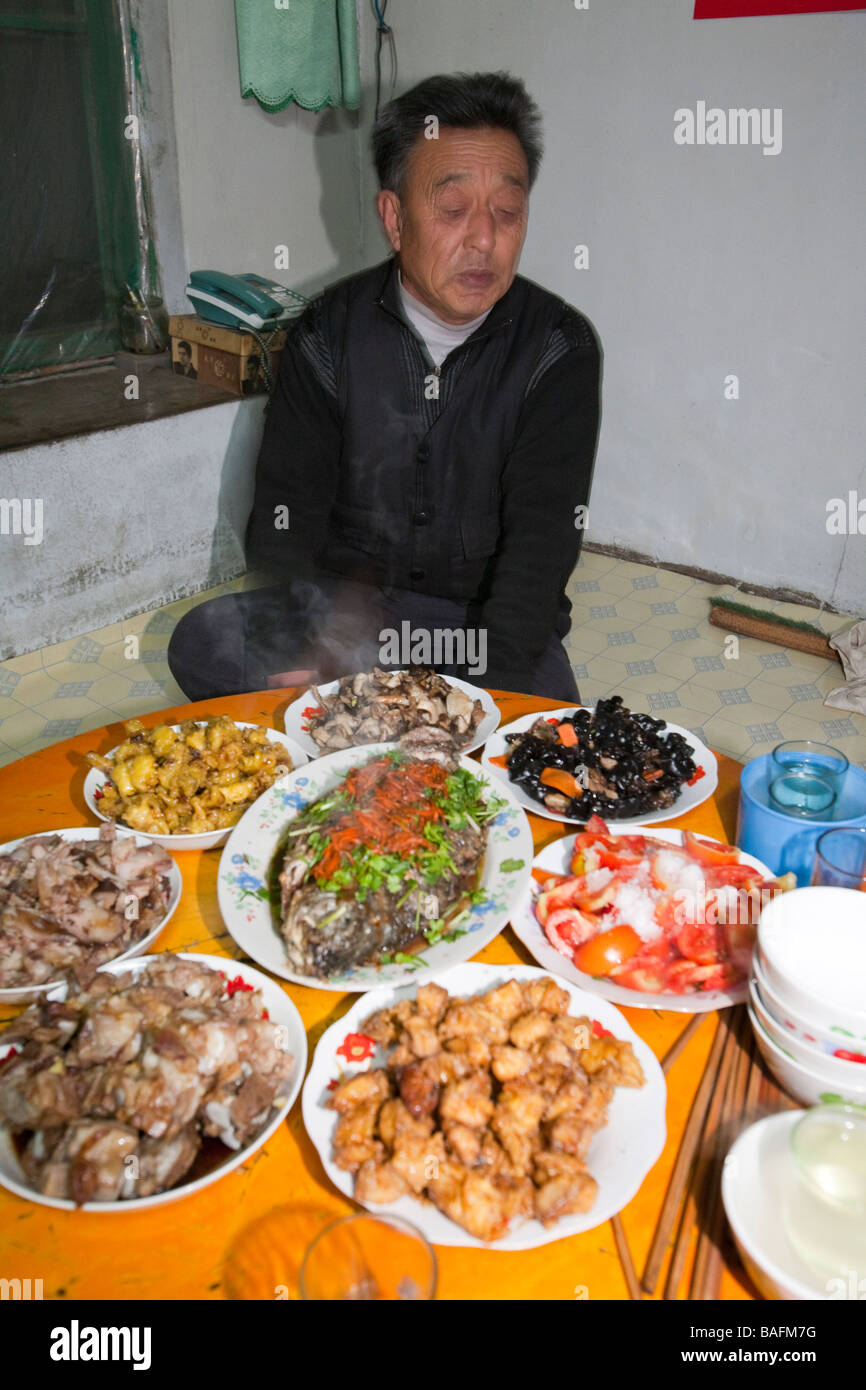 A chinese family sit cross legged for a traditional meal in ...