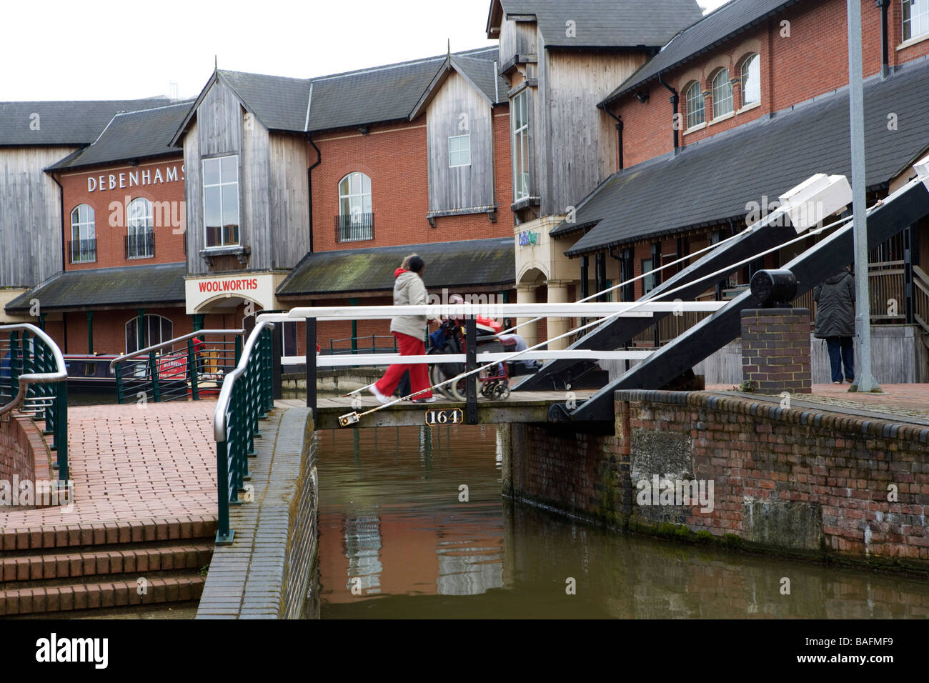 A pedestrian crossing a lift bridge on the Oxford canal in the town of ...