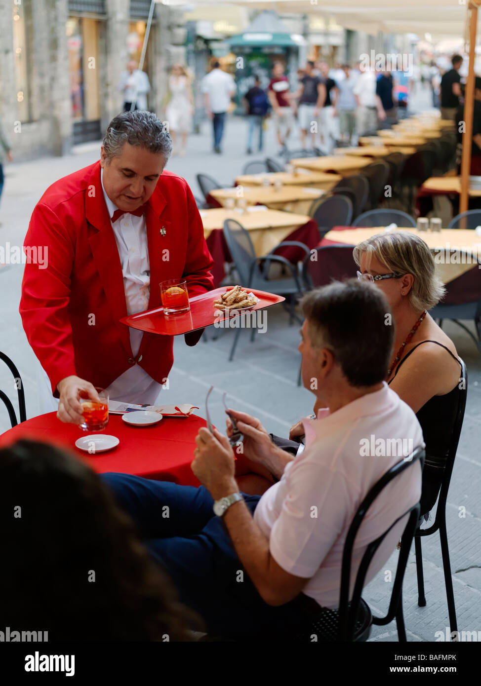 A waiter serves a couple at an outdoor cafe in Italy Stock Photo - Alamy