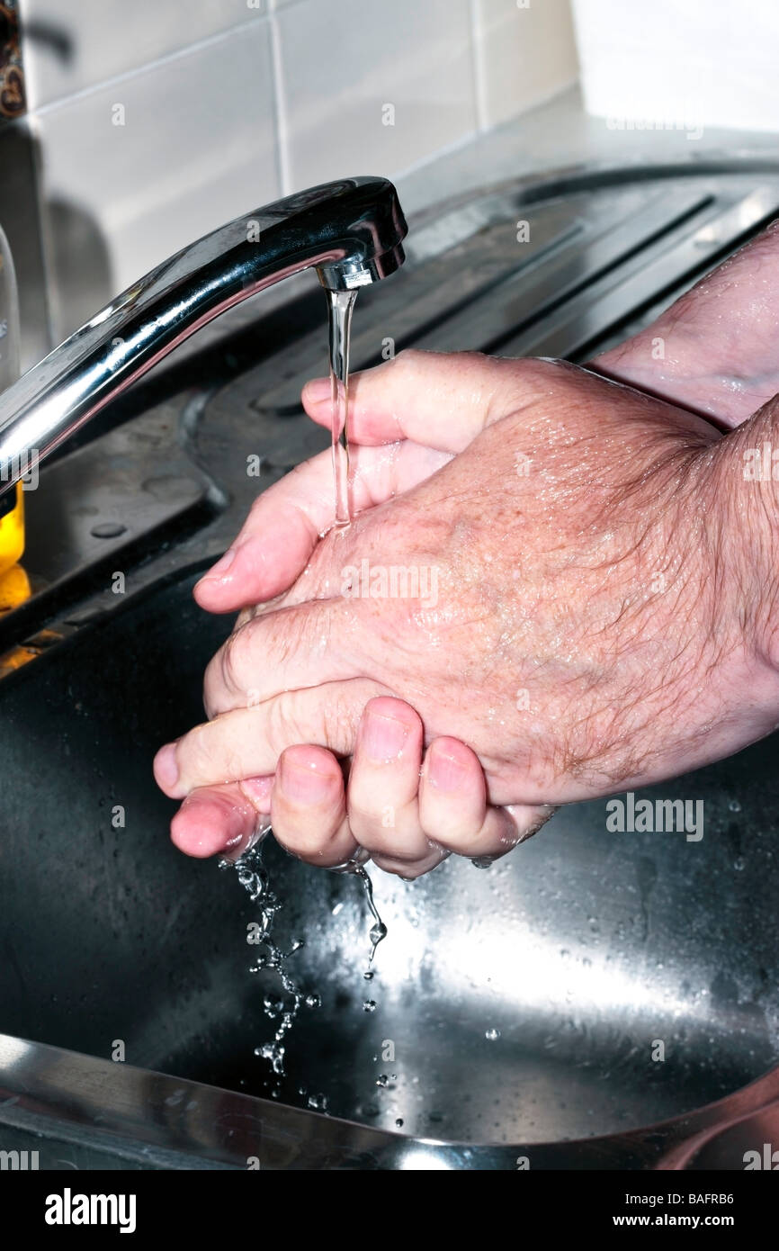 Man Washing hands in running water over kitchen sink Stock Photo - Alamy