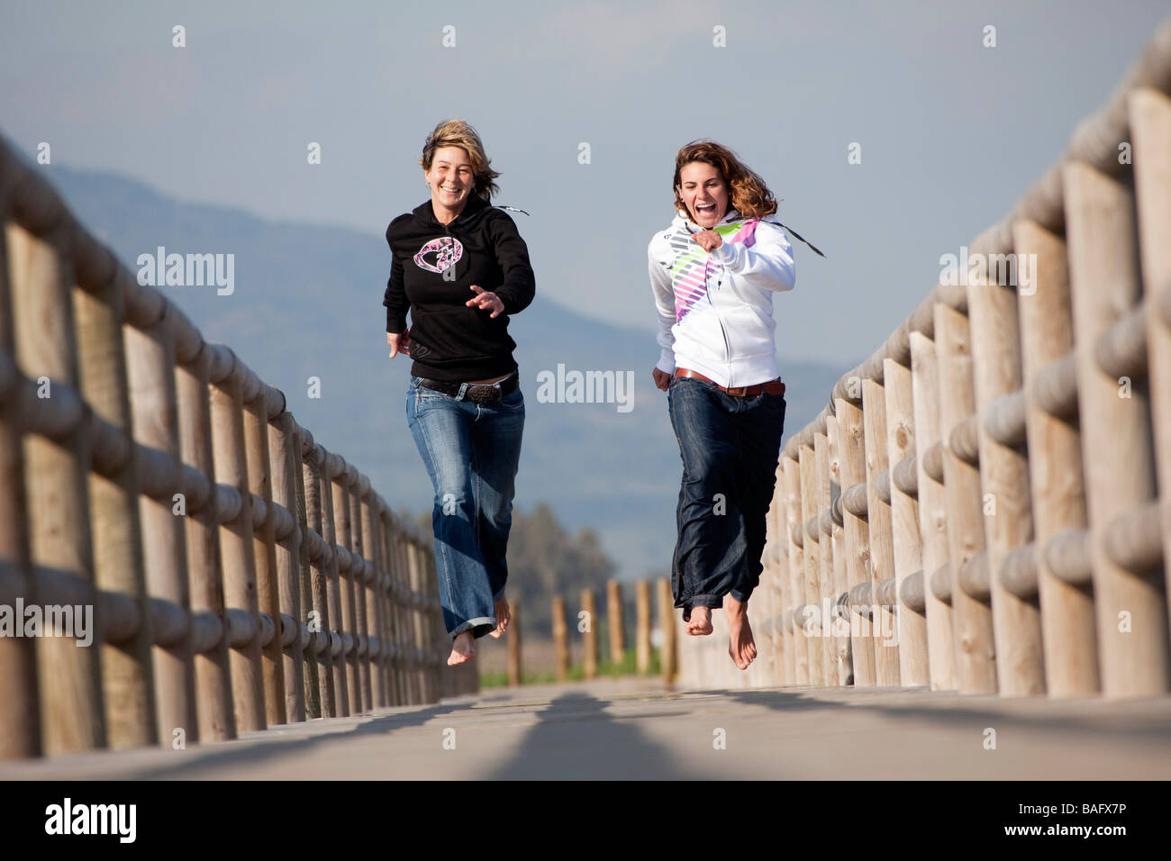 Two friends running barefoot Stock Photo - Alamy