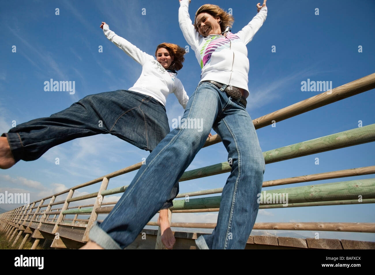 Two women jumping Stock Photo - Alamy