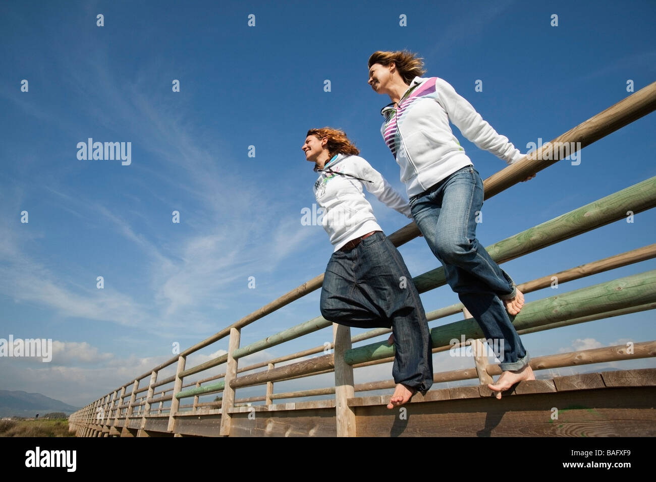 Two women on a railing Stock Photo - Alamy