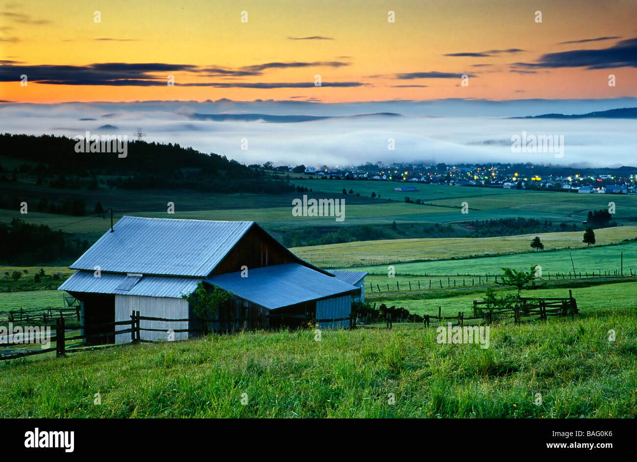 A colorful Canadian landscape of a metal barn in a green field ...