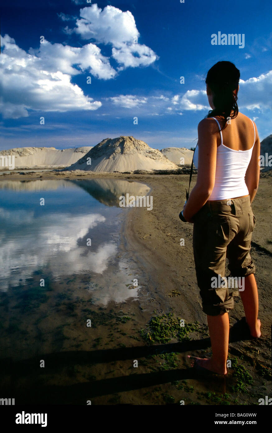 Picture of a young woman outdoors contemplating a landscape with sand ...