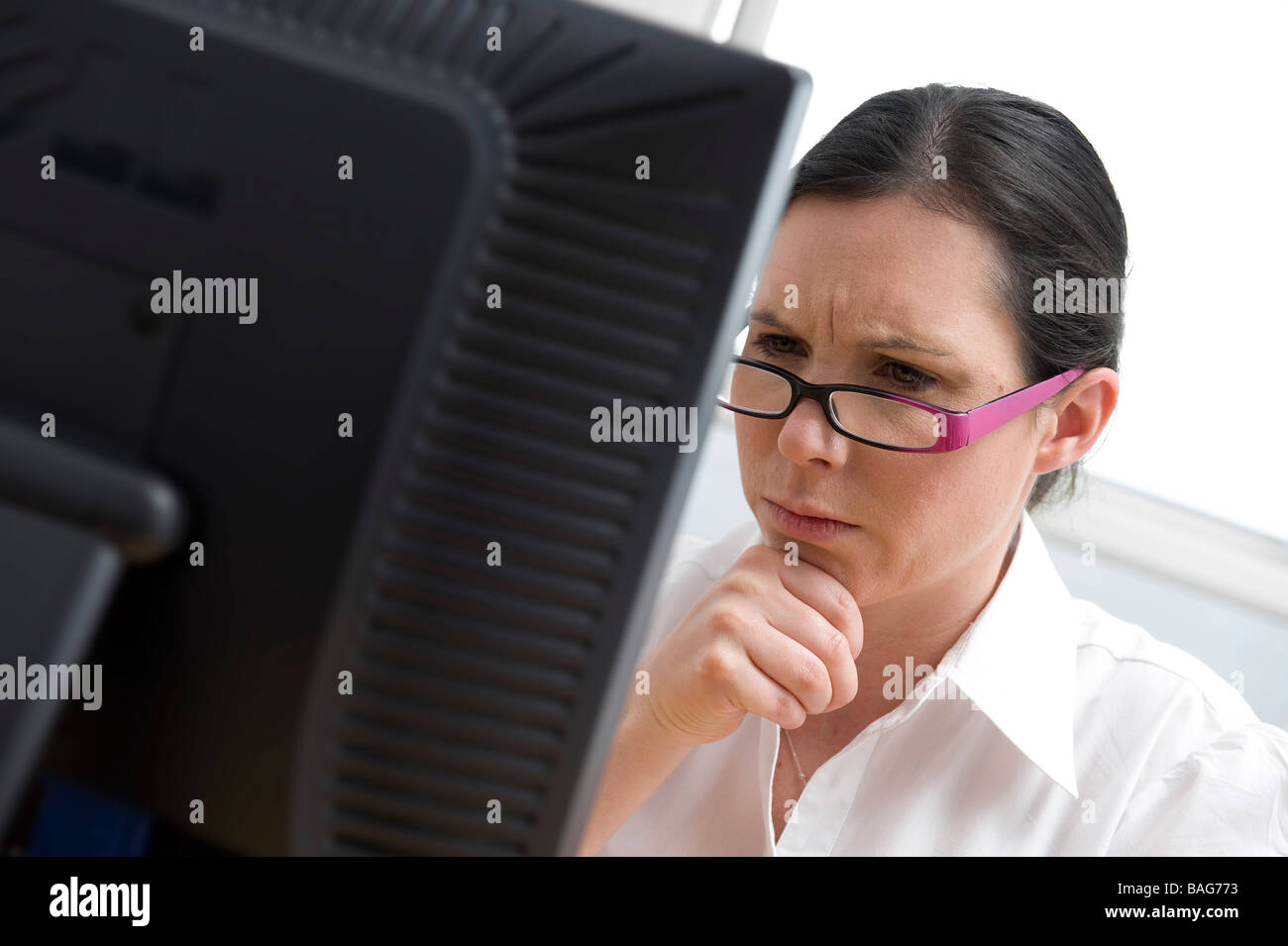 female office worker looking at computer monitor Stock Photo - Alamy